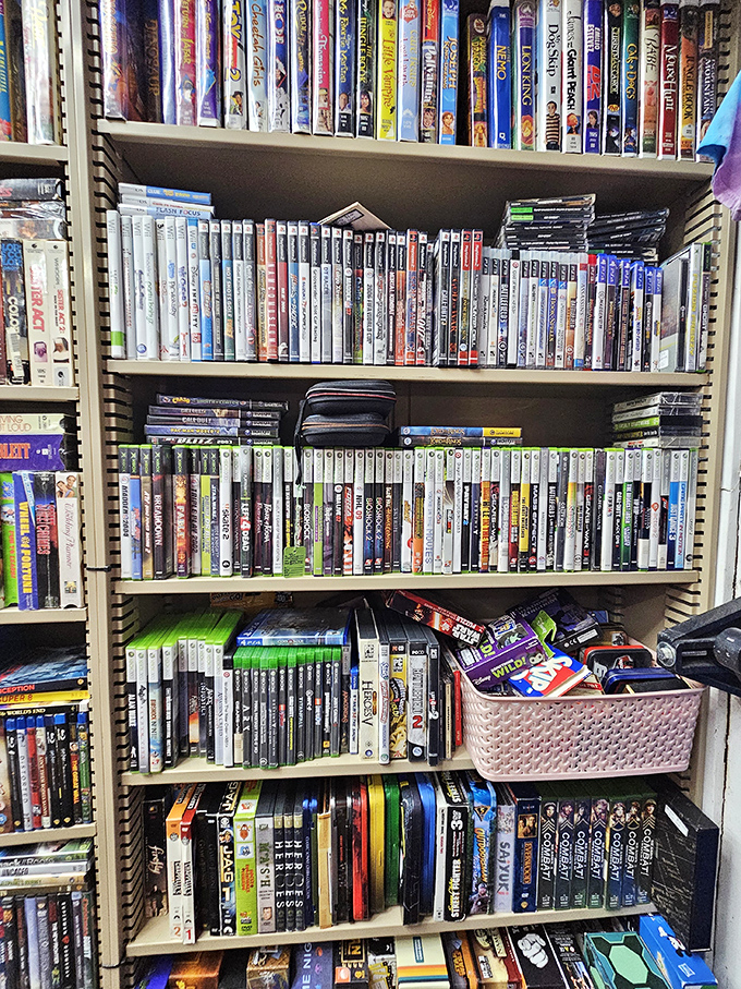A library of forgotten entertainment where DVDs and games await their second act. Marie Kondo would have a panic attack here.