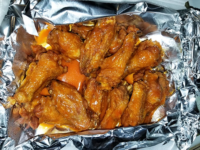 These buffalo wings aren't messing around—glistening with sauce and promising the kind of flavor that makes napkins necessary and regrets impossible.
