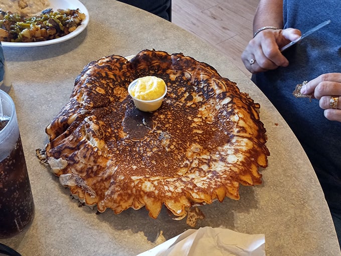 This pancake isn't just big—it's Arizona-sunset big, with edges crispy and center fluffy enough to make your pillow jealous.