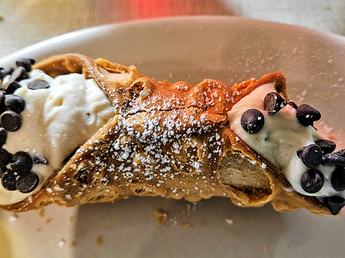 The cannoli – that perfect crispy shell embracing sweet ricotta filling, dusted with powdered sugar and chocolate chips. Resistance is futile.