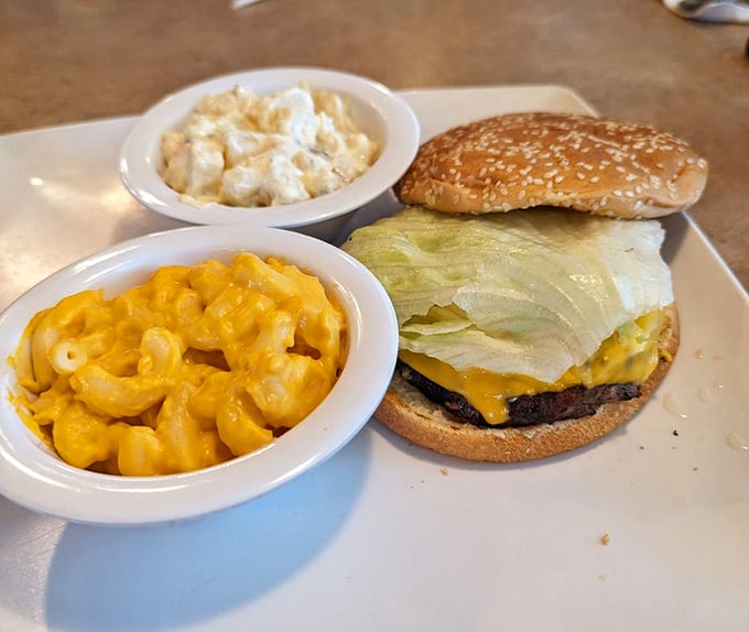 A classic burger with all the fixings, flanked by mac and cheese that's practically glowing with cheesy promise.