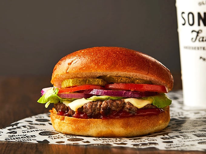 This isn't just a burger – it's a towering masterpiece of beef, cheese, and fresh veggies that makes you want to unhinge your jaw like a python.