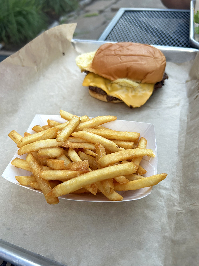 This isn't just a burger—it's architecture you can eat. Fresh lettuce, ripe tomato, and that perfectly charred patty create the skyline of Flavortown.