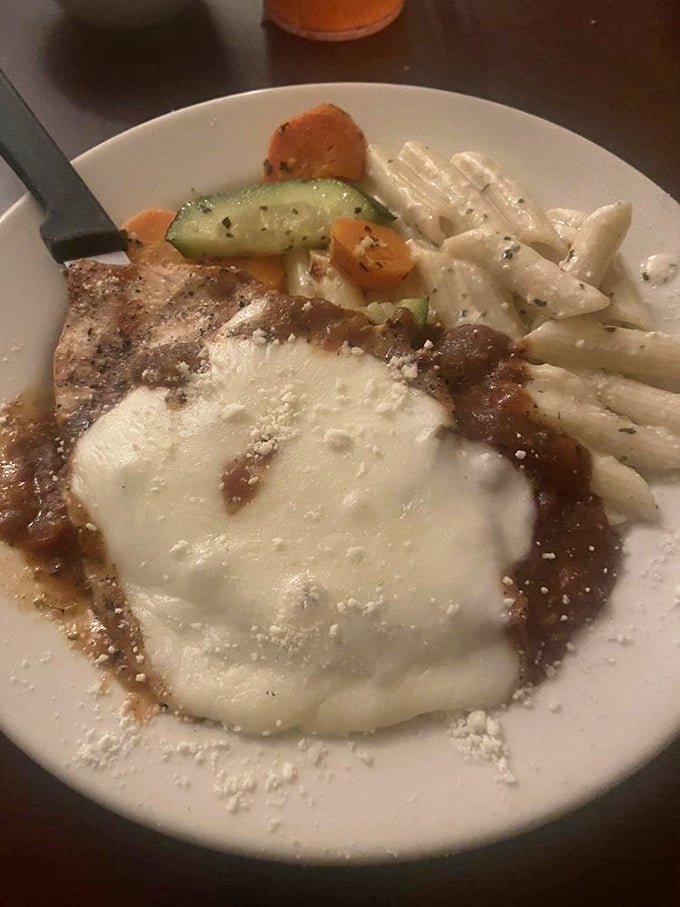 Chicken Parmesan that doesn't hide behind excess—just honest comfort food wearing a perfectly melted cheese blanket and a side of pasta.