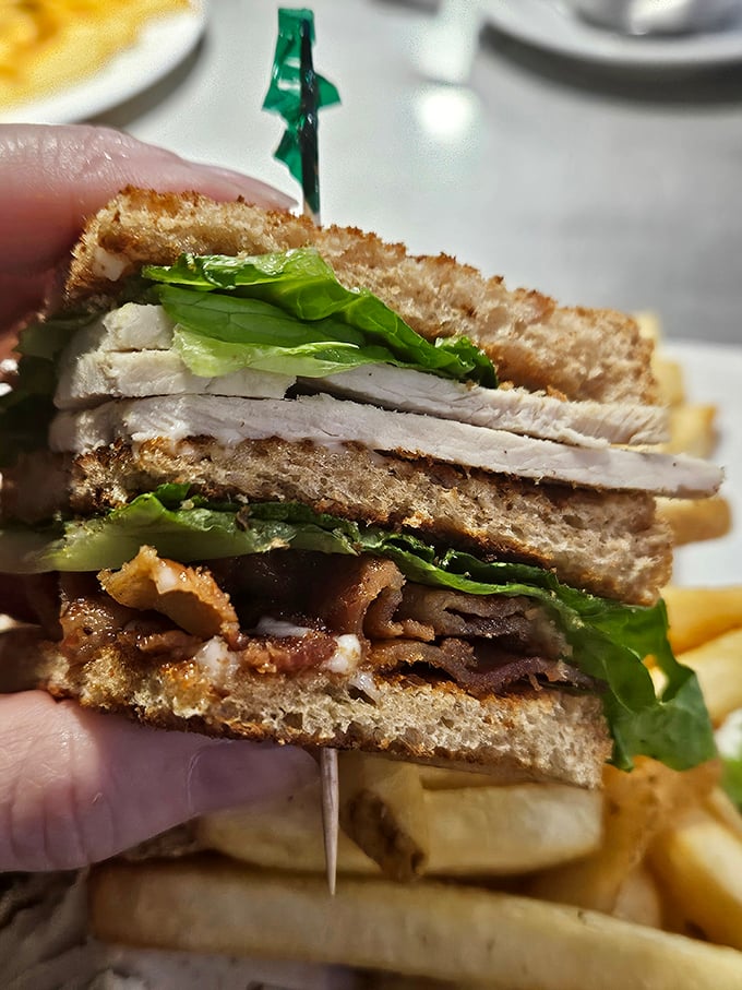 The club sandwich – architecture you can eat! Layers of turkey, bacon, and crisp lettuce create the skyscraper of sandwiches, secured with that iconic toothpick.