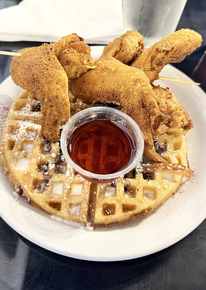The chicken and waffle situation here is serious business—crispy golden bird perched atop a fluffy waffle with honey waiting in the wings.