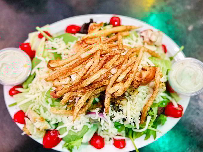 Even the salads mean business here. Fresh greens topped with crispy fries—because vegetables should have fun too.