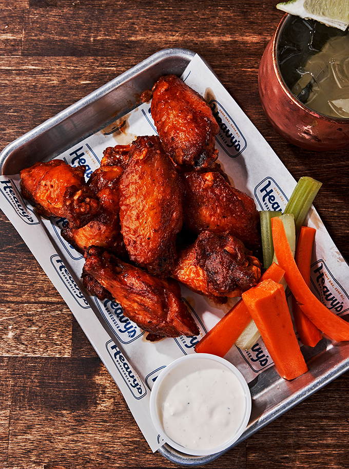 These wings aren't just tossed in sauce—they're baptized in it. Served with veggies that pretend you're making healthy choices.