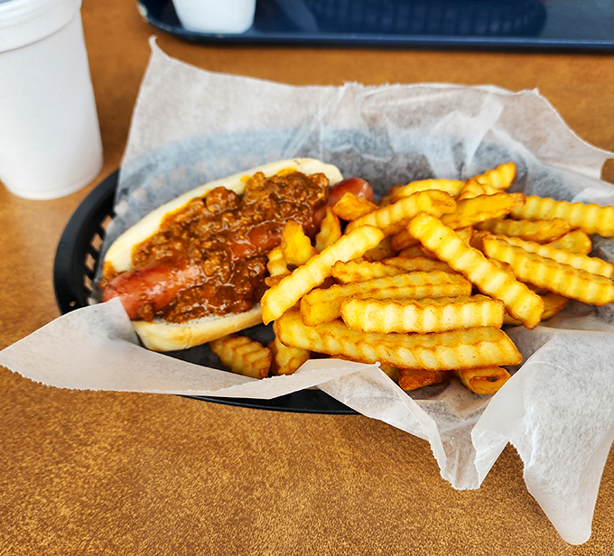 The humble hot dog elevated to art form – where chili, bun, and dog achieve perfect harmony like a culinary jazz trio.