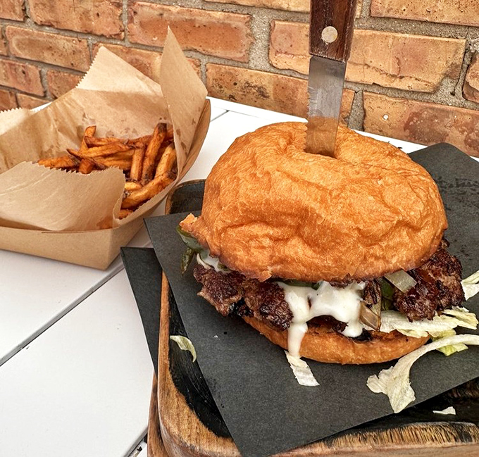 The Chili Queen arrives on her slate throne, ready to rule your taste buds. Those hand-cut fries standing at attention know they're in the presence of burger royalty.