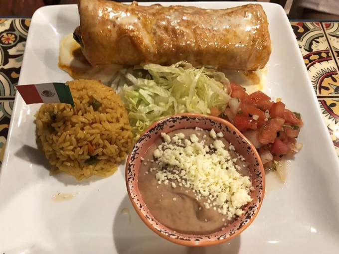 This chimichanga isn't messing around—golden-fried perfection flanked by rice that actually tastes like something and beans worthy of their own spotlight.