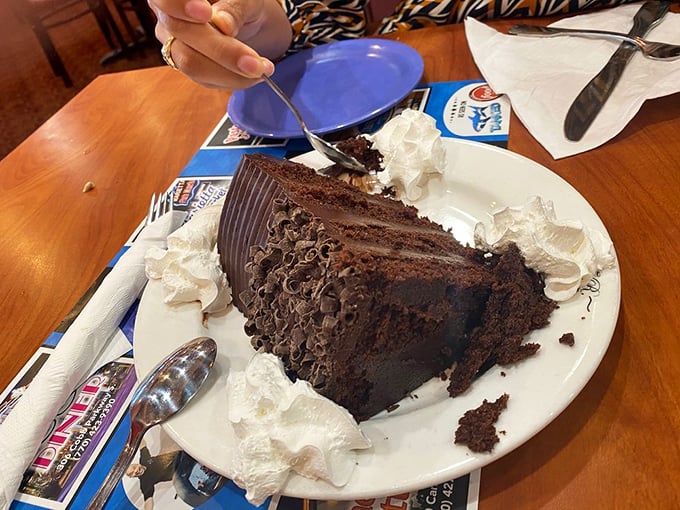 A chocolate cake so decadent it should come with a warning label. That whipped cream perimeter isn't decoration—it's crowd control.