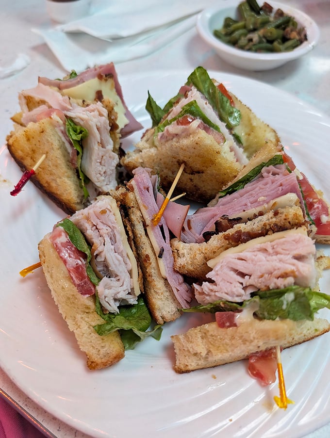 A club sandwich that requires engineering skills to eat—layers of fresh ingredients held together by toothpicks and optimism.