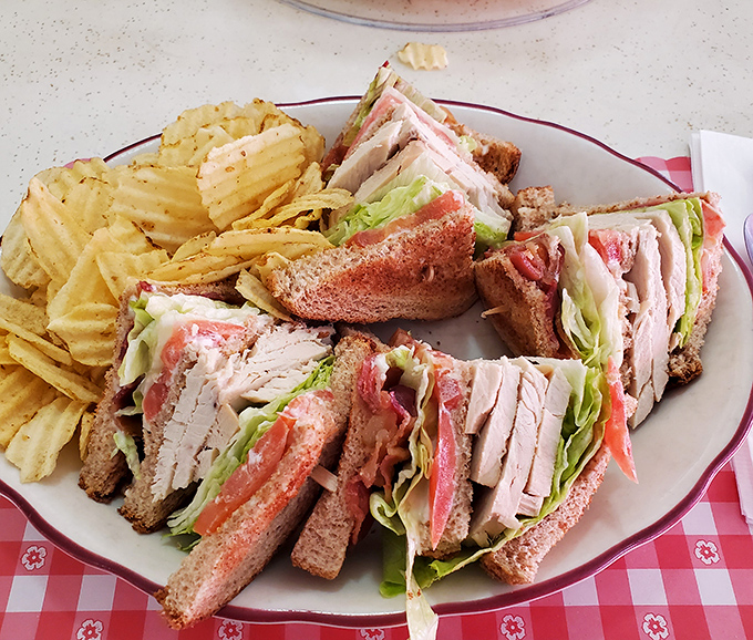 The club sandwich—an architectural marvel of turkey, bacon, and structural integrity that makes modern small plates look like a practical joke.