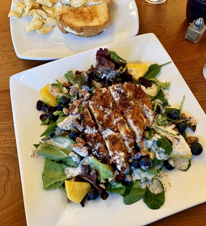 A salad that makes you forget you're eating healthy – grilled chicken, fresh greens, and berries playing together like old friends at a delicious reunion.