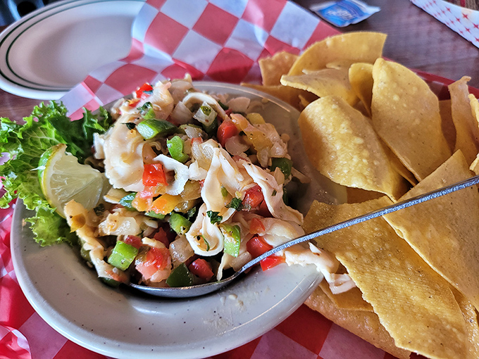 Conch ceviche that dances with color and freshness. Those tortilla chips aren't just sides—they're edible spoons for ocean-kissed perfection.