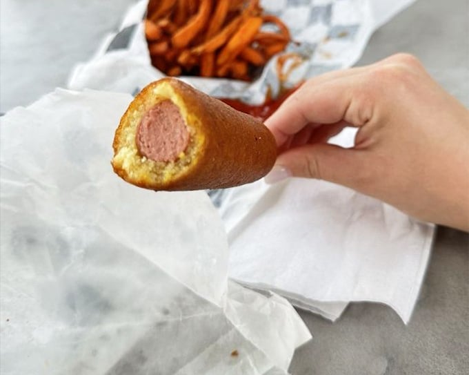This corn dog isn't just carnival food; it's nostalgia on a stick. The perfect golden-brown exterior gives way to that satisfying snap with each bite.