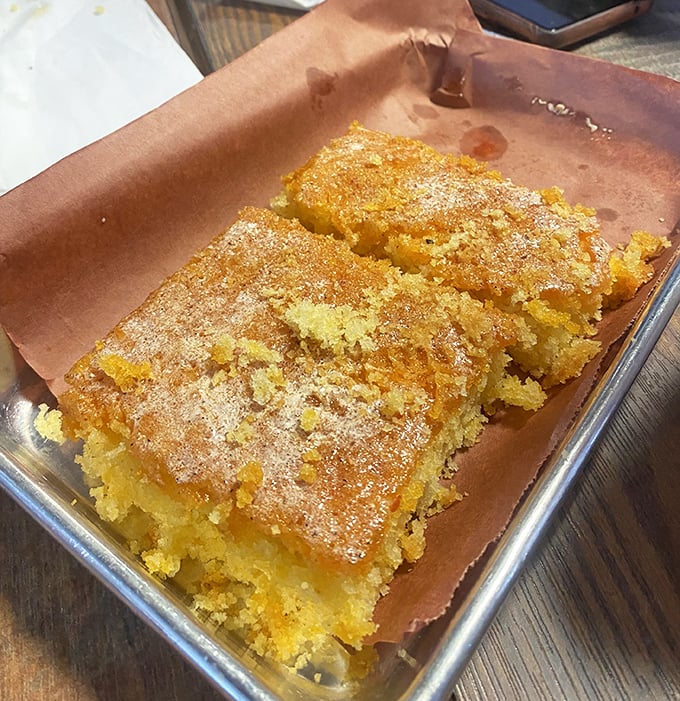 Golden cornbread with a sugary crust that shatters just right—the perfect vehicle for sopping up every last drop of BBQ sauce.