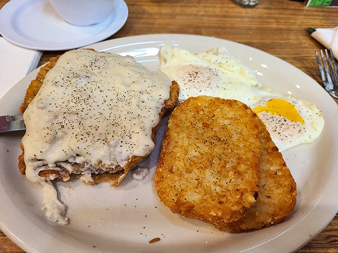 Country fried steak smothered in gravy with hash browns and eggs—the breakfast of champions who plan to skip lunch entirely.