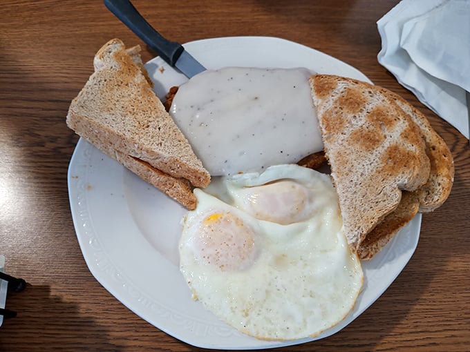 Breakfast done right doesn't need fancy tricks—just perfectly cooked eggs, toast, and a generous portion of country-fried goodness.