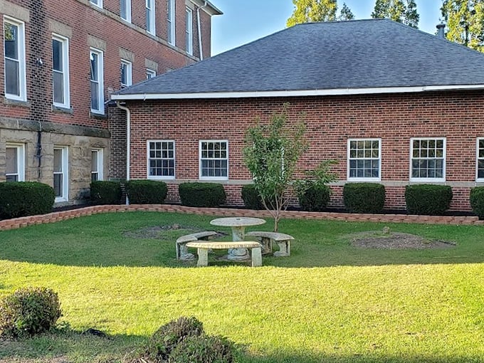 A peaceful courtyard offers a momentary reprieve from the building's intensity. The stone table—a place for reflection or perhaps ghostly gatherings?