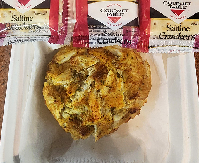 A proper Maryland crab cake—mostly crab, minimal filler, maximum flavor—served with saltines because sometimes perfection needs no embellishment.