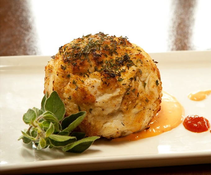 Not all heroes wear capes—some come disguised as crab cakes with a golden crust that shatters like delicious culinary glass.