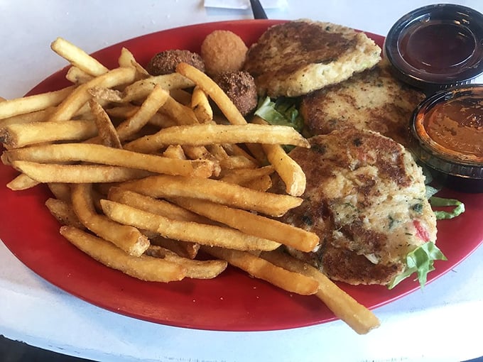 Golden-brown crab cakes that don't hide behind fillers—just pure crabby goodness with a side of crispy fries that demand attention.