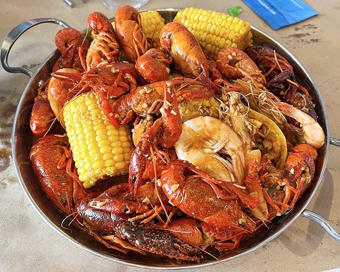 A crimson sea of crawfish and shrimp with corn lifeboats. This isn't just dinner—it's an expedition worth documenting.