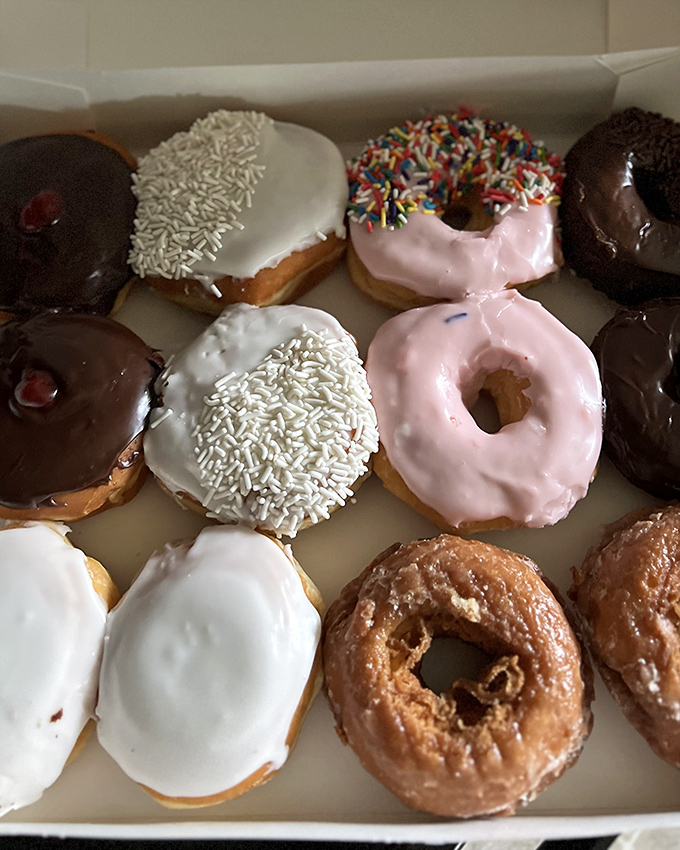 Heaven's waiting room looks suspiciously like this box of assorted donuts, where chocolate, sprinkles, and glazed varieties coexist in perfect harmony.