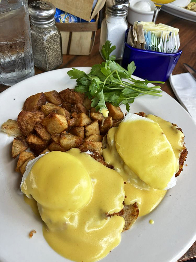 Eggs Benedict done right—hollandaise cascading like a golden waterfall over perfectly poached eggs. Breakfast architecture at its finest.