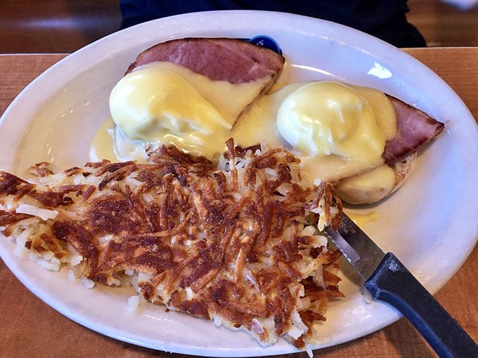 Eggs Benedict with ham and crispy hash browns—the breakfast equivalent of a power suit. This plate means business, delicious business.