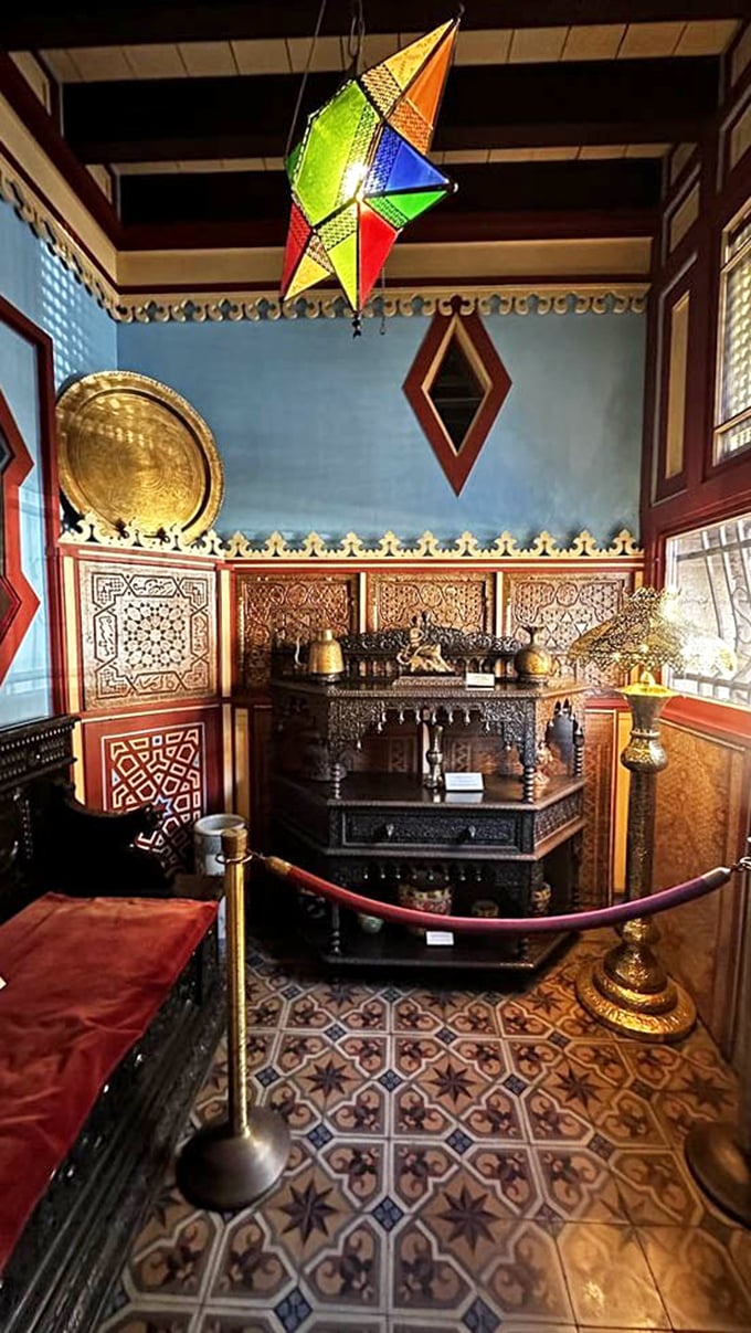 Colorful lanterns cast magical patterns across this room's blue walls and ornate furnishings—proof that maximalism worked beautifully long before it became an Instagram trend.