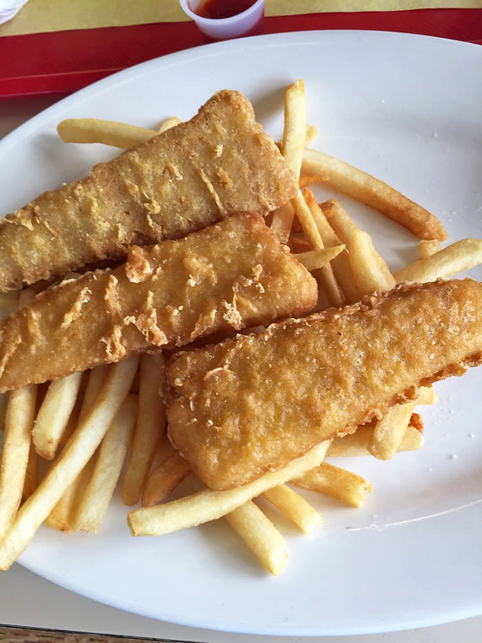 Golden-battered fish fillets lounging on a bed of crispy fries—seafood and potatoes having their best day ever.