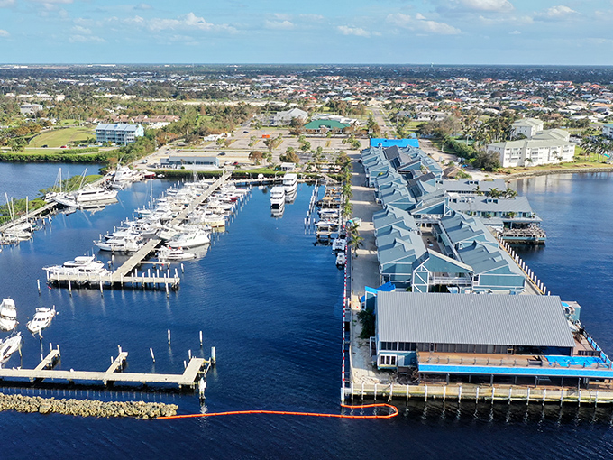 From above, Fishermen's Village reveals its true character—a perfect marriage of marina functionality and vacation-worthy blue rooftops stretching into the harbor.