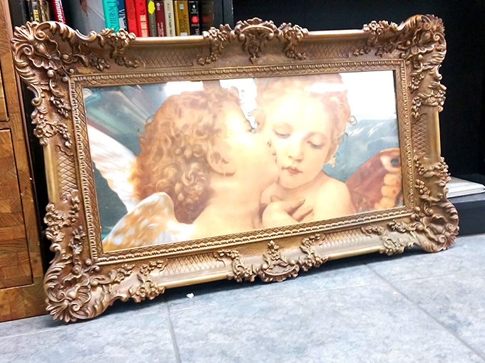 Someone's cherished angels found their way here, ornate frame and all. Tomorrow, they could be watching over your living room.