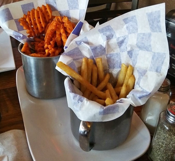 Regular and sweet potato fries served in metal cups—because sometimes the hardest choice in life is which potato to eat first.