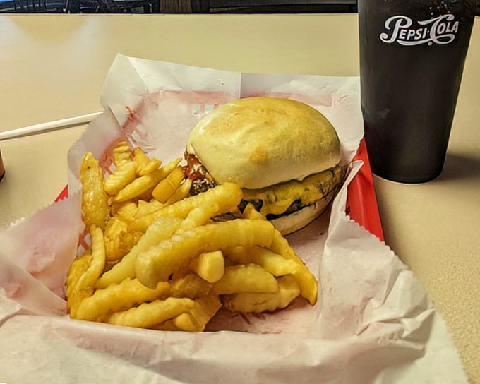 The burger that launched a thousand road trips, nestled beside crinkle-cut fries that somehow taste better in a red basket.