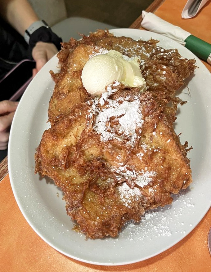 French toast that's had a spa treatment—golden, crispy exterior with a custardy soul, topped with butter melting like a snowflake in Phoenix.