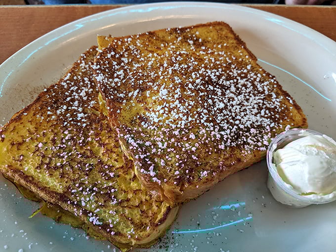 French toast dusted with powdered sugar like fresh snow, with a butter pat melting into golden perfection. Breakfast or dessert? Yes.
