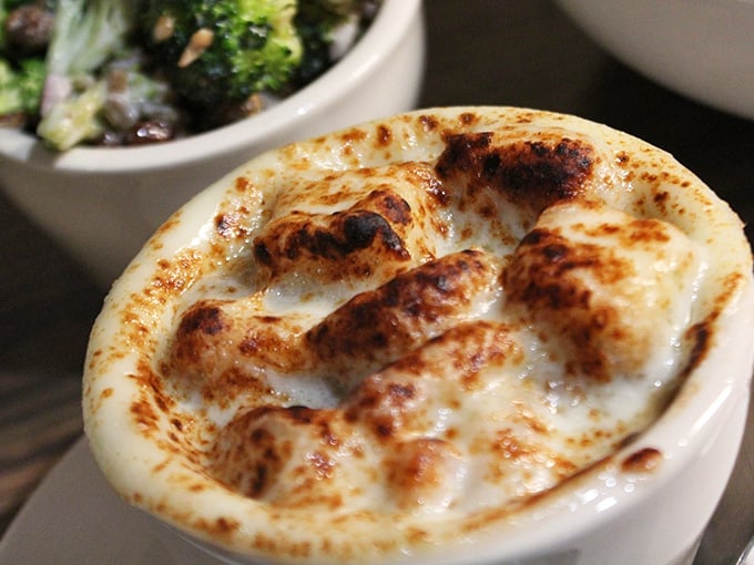 This isn't just French onion soup—it's a bubbling cauldron of cheese-capped comfort that demands to be broken into with gleeful abandon.