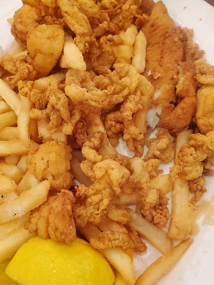 Golden-fried clam strips and crispy fries—the kind of plate that makes you wonder why you ever bother with fancy food when simple perfection exists.