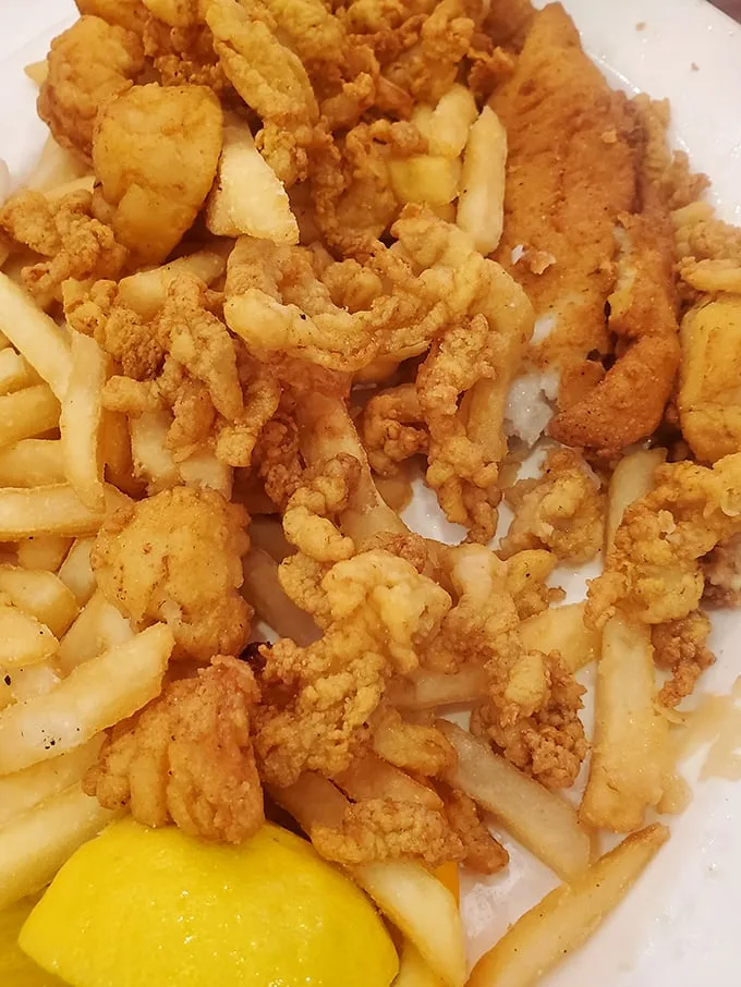 Golden-fried clam strips and crispy fries—the kind of plate that makes you wonder why you ever bother with fancy food when simple perfection exists.