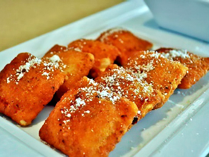 Fried ravioli – because regular ravioli wasn't indulgent enough. These golden pillows dusted with parmesan are what appetizer dreams are made of.
