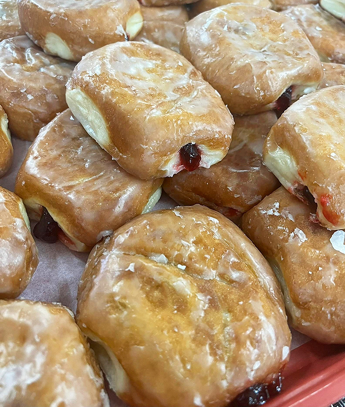 Jelly-filled treasures glistening with glaze. The surprise inside is worth the potential shirt casualty every single time.