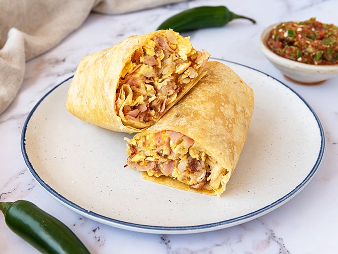 The ham breakfast burrito—where morning protein meets pillowy eggs in a tortilla embrace. Like a warm hug from a friend who really gets you.
