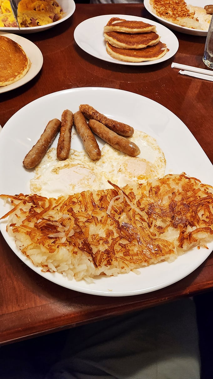 The breakfast trifecta: perfectly crispy hash browns, eggs sunny-side up, and sausage links. A plate that says "good morning" better than words ever could.