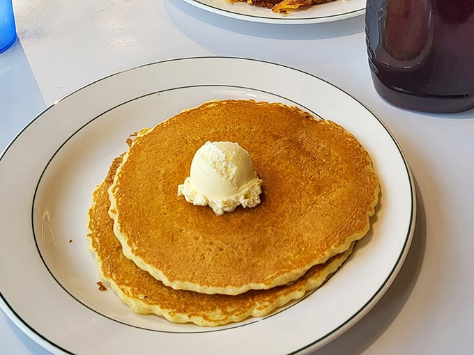 Golden pancakes that look like they were painted by Norman Rockwell himself. That melting butter pat is performing a slow, beautiful dance.