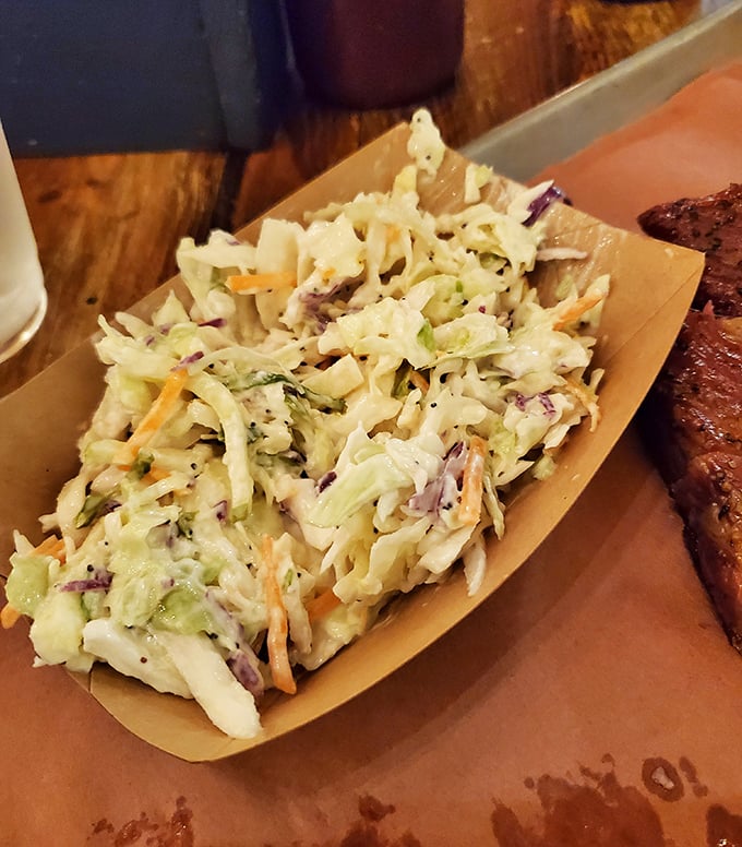Not just any coleslaw – lemon poppyseed coleslaw. The bright, crunchy counterpoint that cuts through rich BBQ like a well-timed punchline.