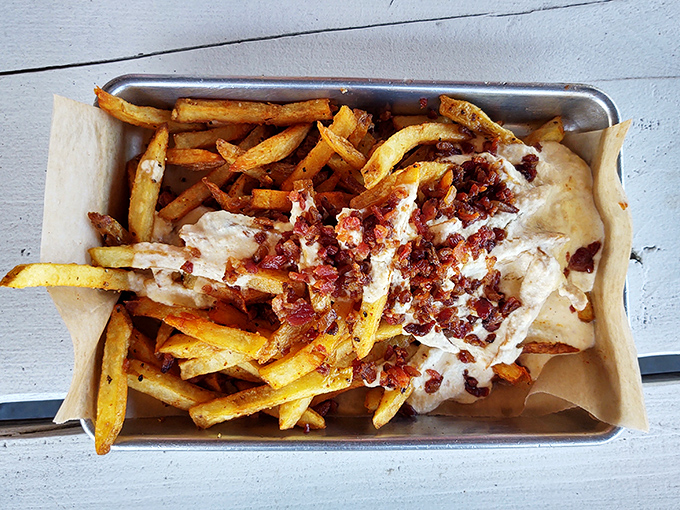 These loaded fries aren't just a side – they're a main event dressed in bacon bits and cheese sauce, waiting to steal the spotlight from your entrée.